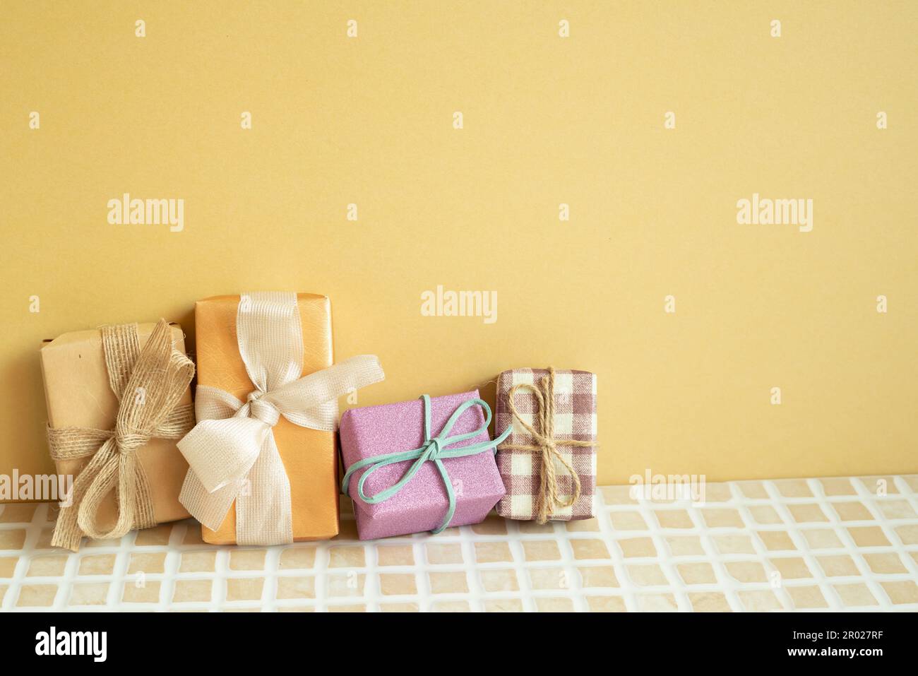 Gift boxes on table. yellow background. anniversary birthday party ...