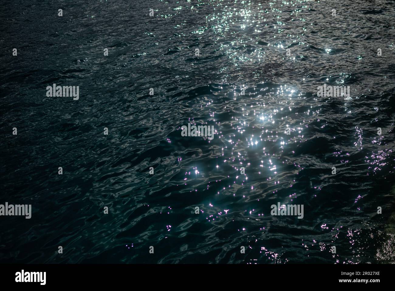 Mostly blurred shimmering water background. Sparkling sea waves surface ...