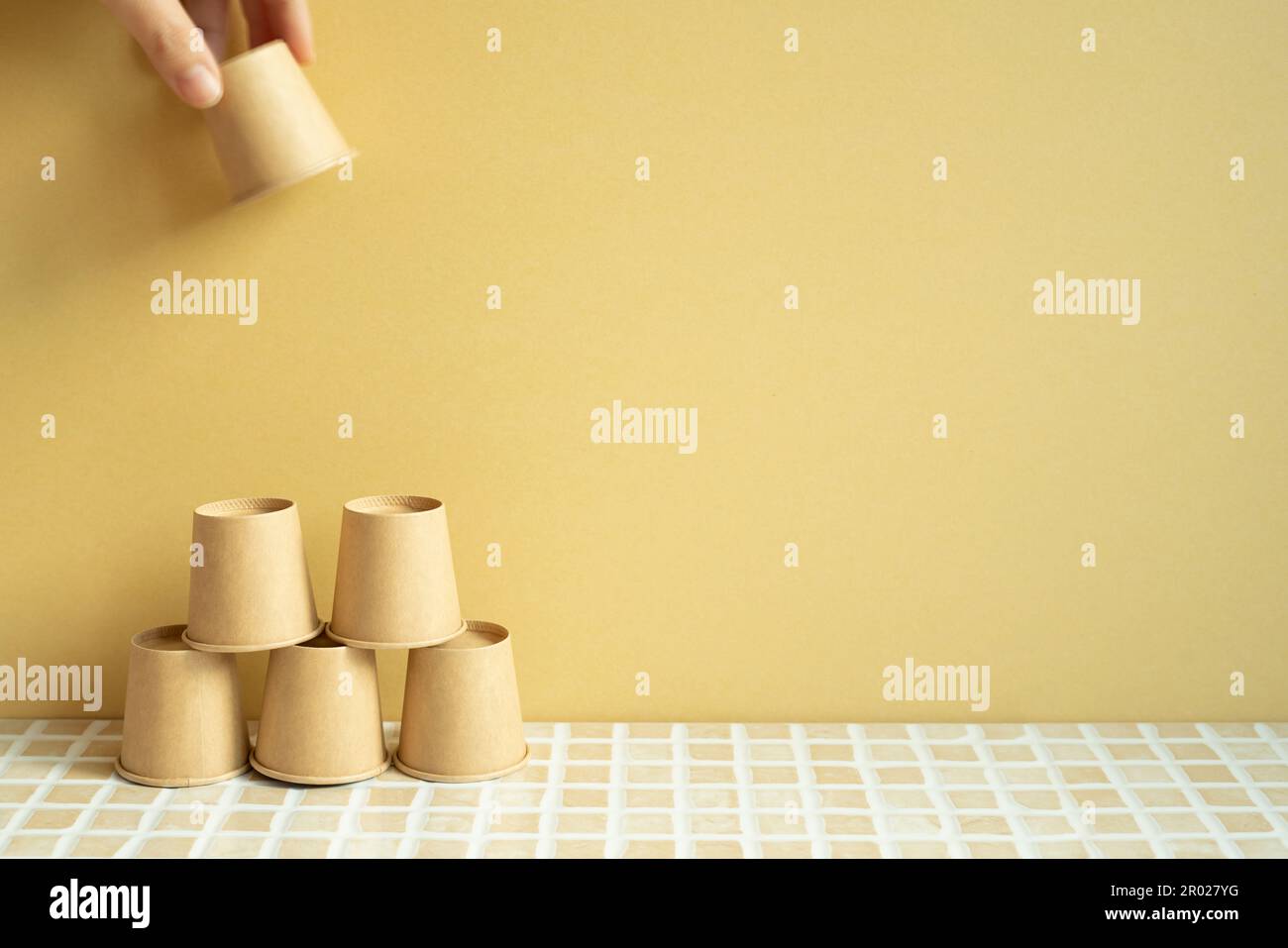 Pyramid stack of brown cup on desk. yellow background. business develop ...