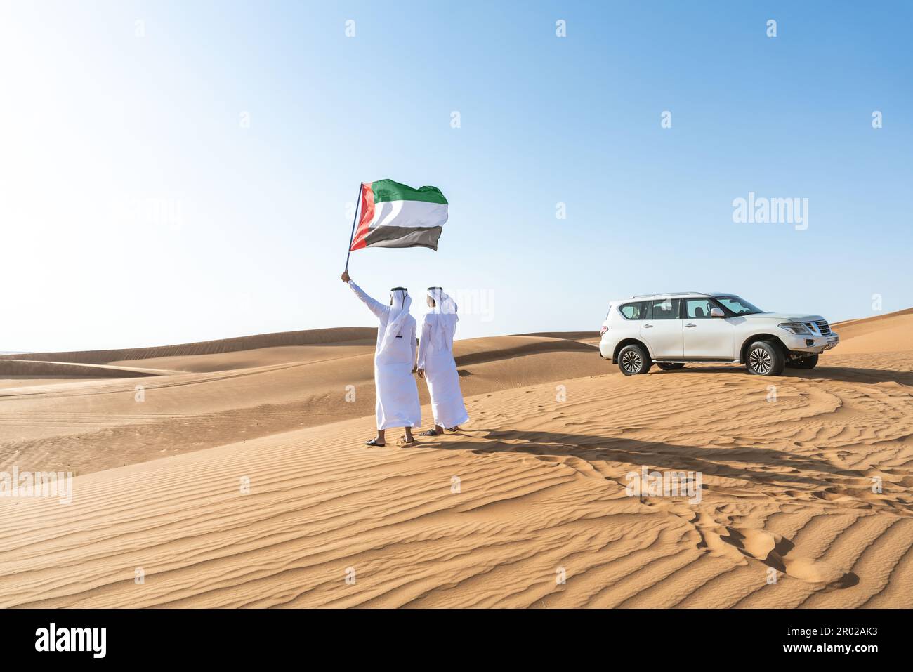 Two middle-eastern men wearing traditional emirati arab kandura bonding ...