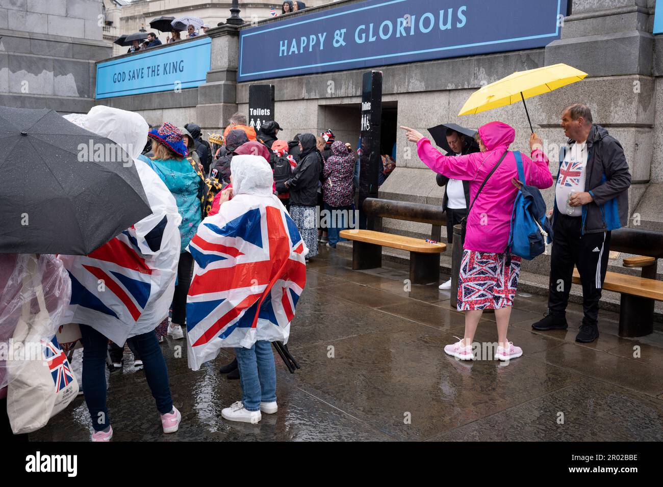 Beneath the banner proclaiming 'Happy And Glorious', members of the public queue for the toilets ...