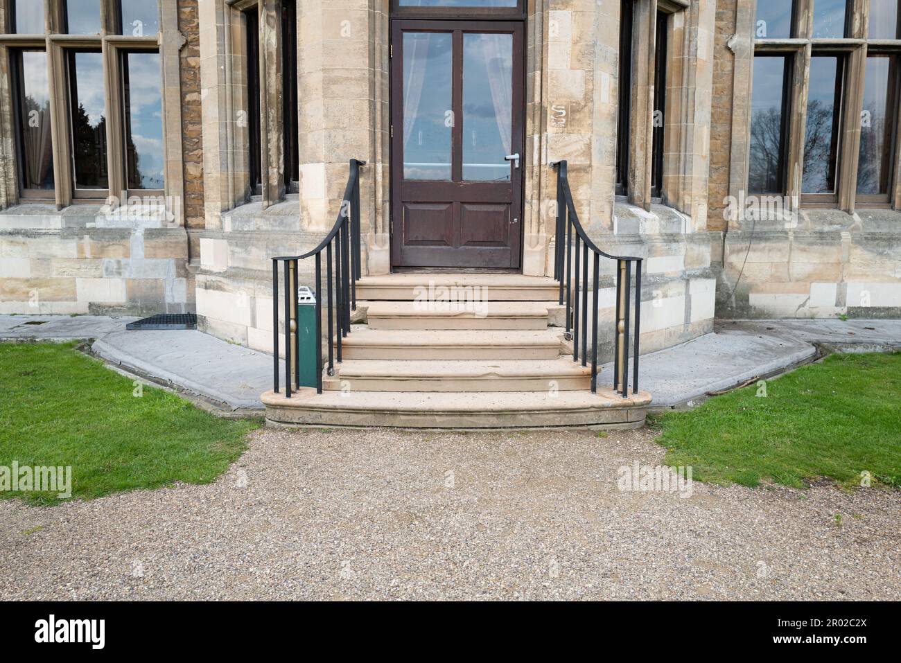 Rear entrance to an old, large English mansion showing the ornate steps ...