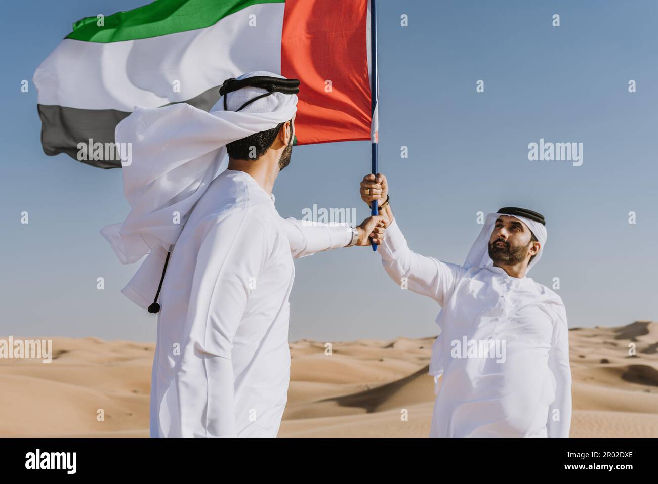 Two middle-eastern men wearing traditional emirati arab kandura bonding ...