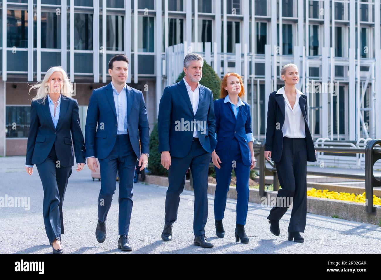 Leadership in Action: A Group of Five Executives Walking and Laughing ...