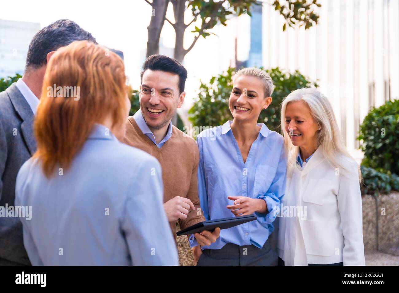 Cheerful group of coworkers laughing and having fun outdoors in a ...