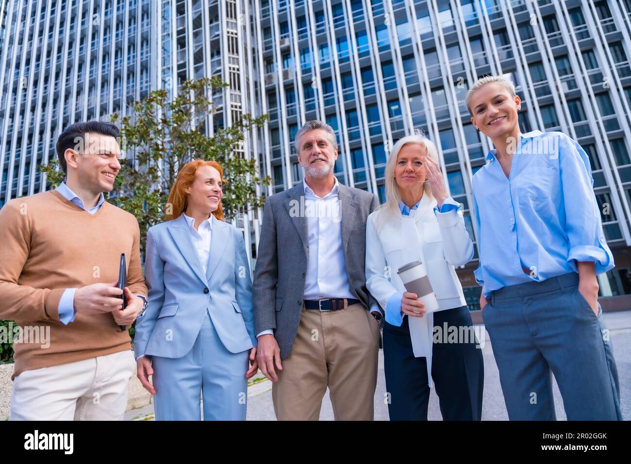 Group of coworkers walking going to work outdoors in a corporate office ...