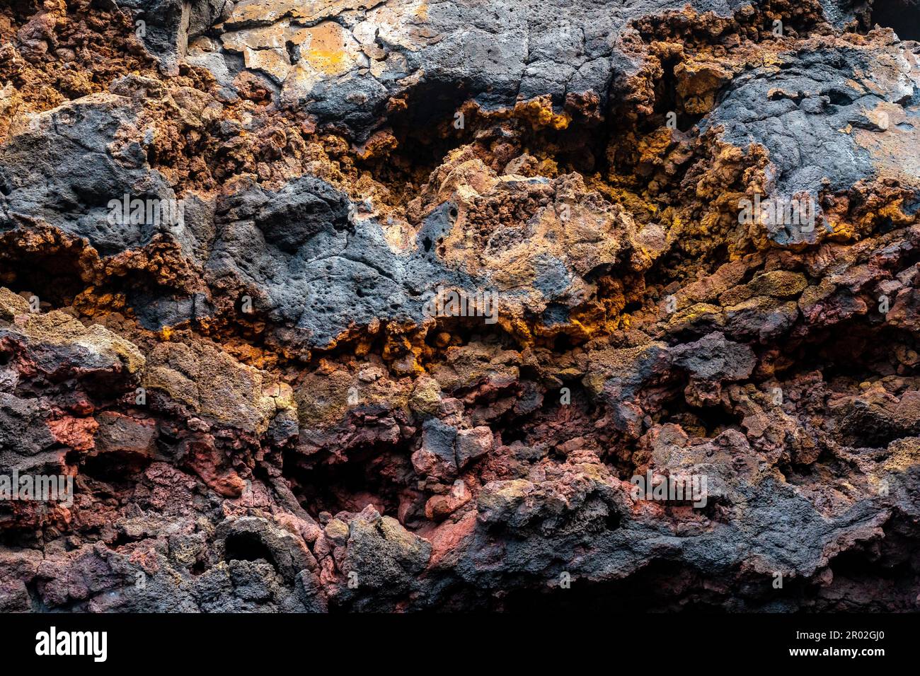 Detail of the red and yellow colors in the volcanic stones in Charco ...