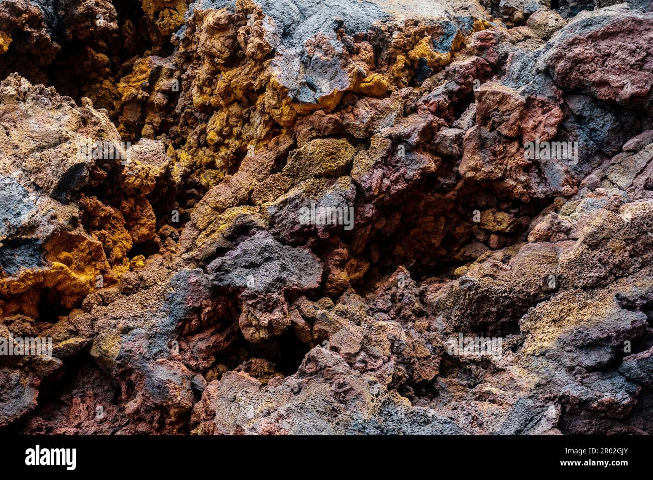 Detail of the red and yellow colors in the volcanic stones in Charco ...