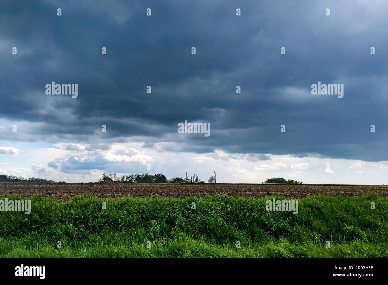 Dark rain clouds hovering over arable land field for agriculture ...