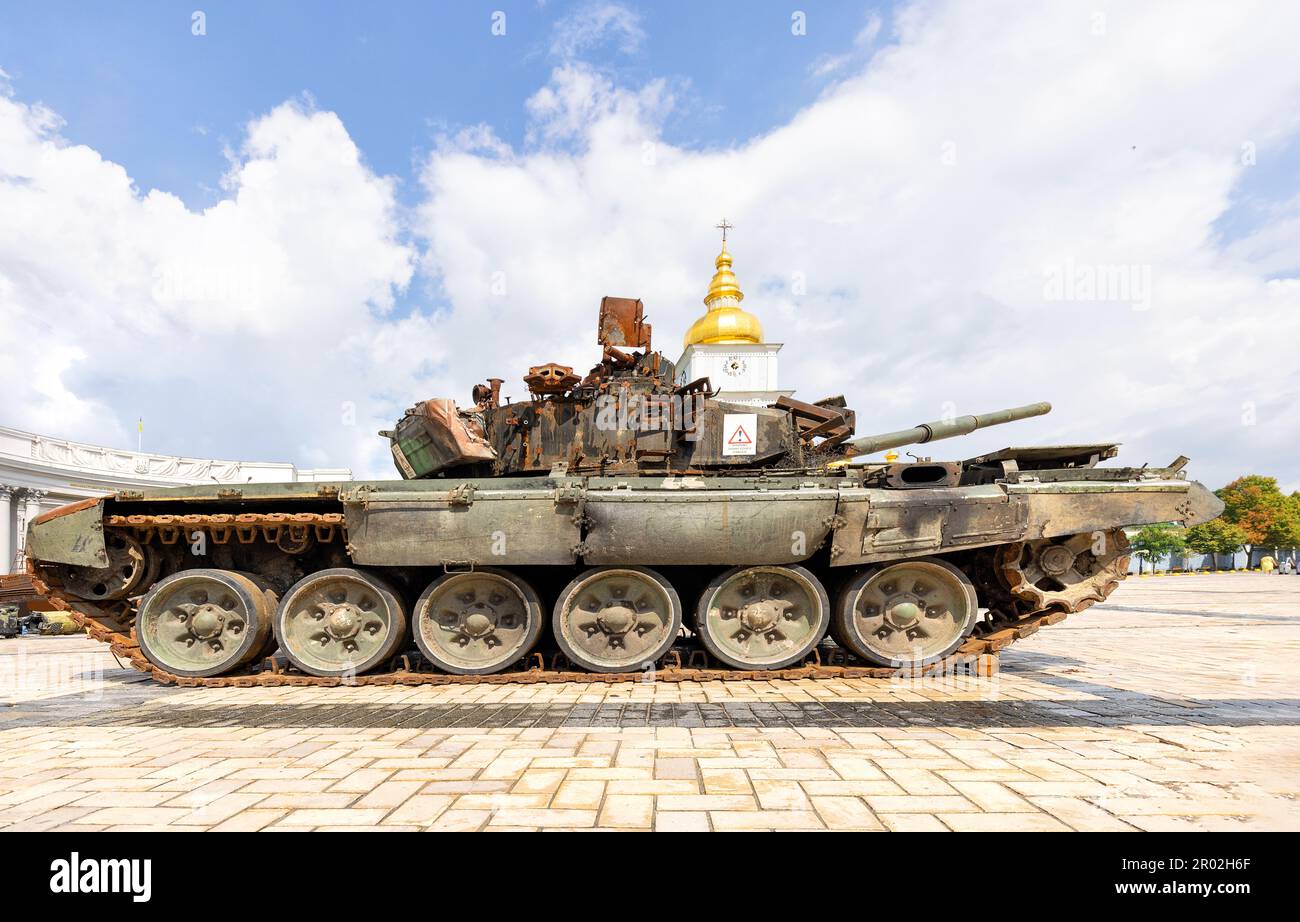 A wrecked rusty Russian tank against the backdrop of a blue sky and the ...