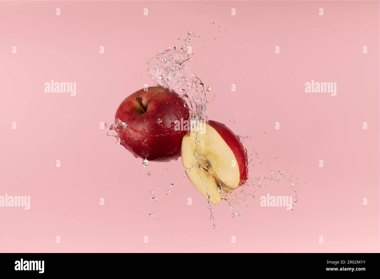 Fresh red apples on pink background with water splash Stock Photo - Alamy
