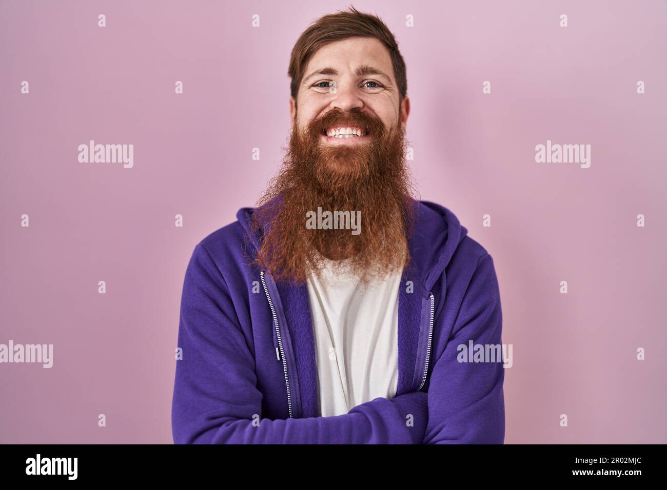 Caucasian man with long beard standing over pink background happy face ...