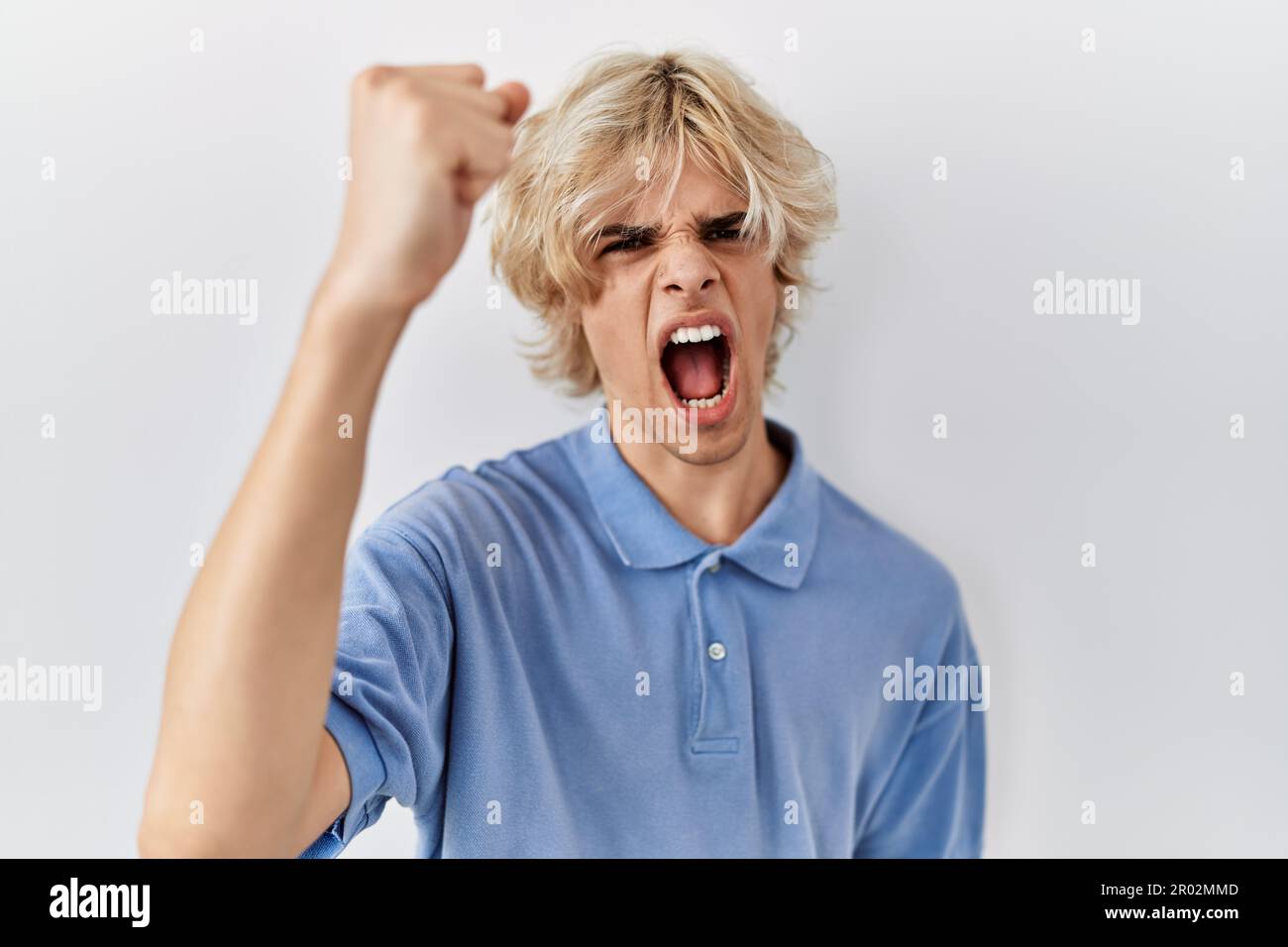 Young modern man standing over isolated background angry and mad ...