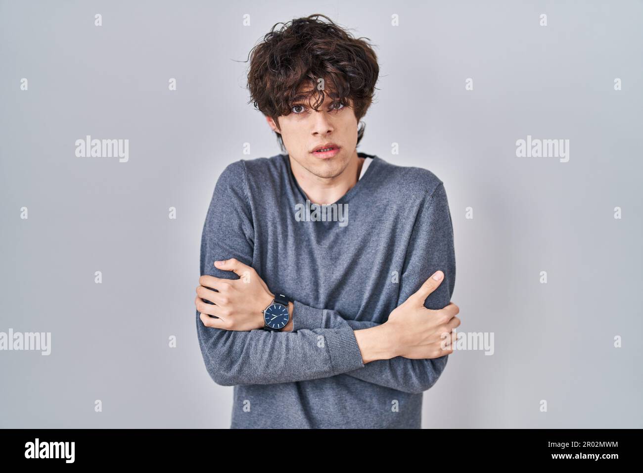 Young man standing over isolated background shaking and freezing for ...