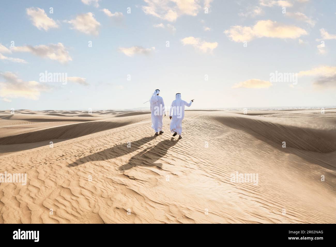 Two middle-eastern men wearing traditional emirati arab kandura bonding ...