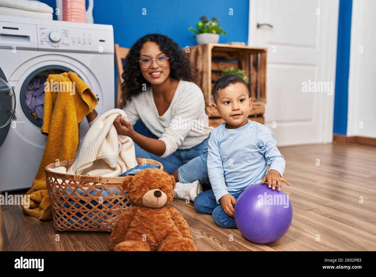 Mother and son smiling confident washing clothes at laundry room Stock ...
