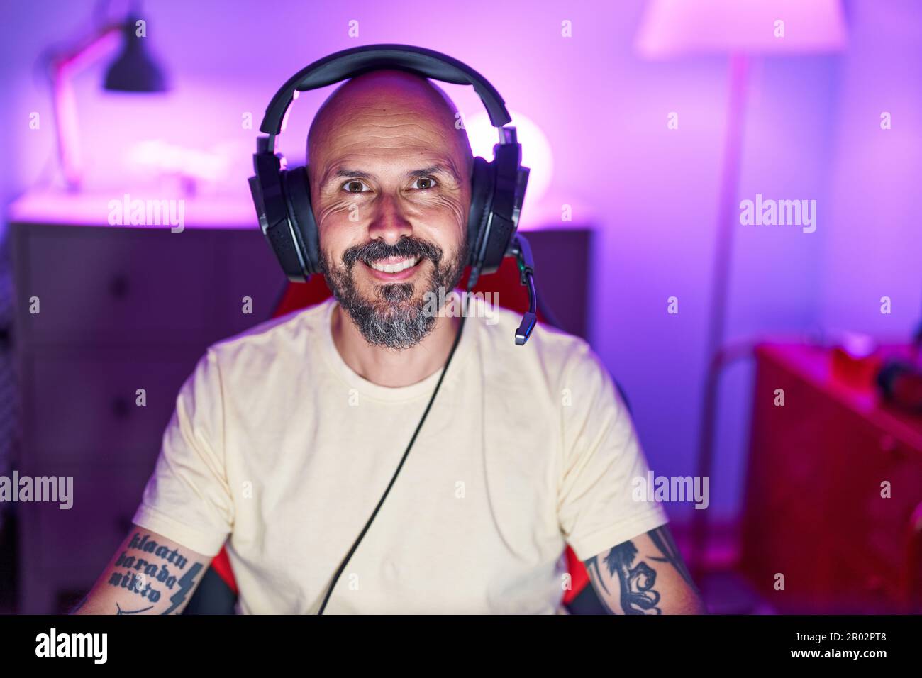 Young bald man streamer smiling confident sitting on table at gaming ...