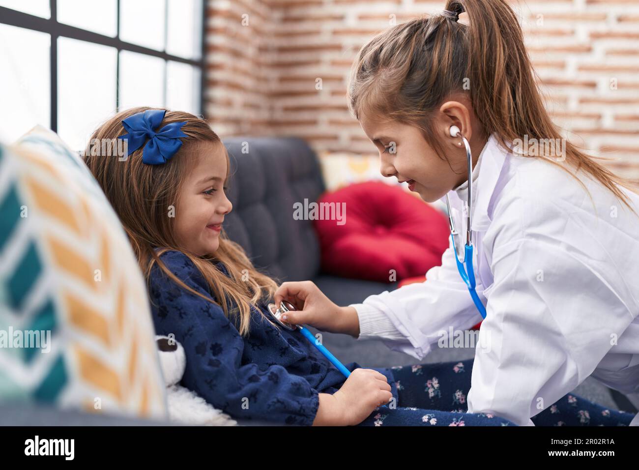 Adorable girls wearing doctor uniform examining with stethoscope at ...