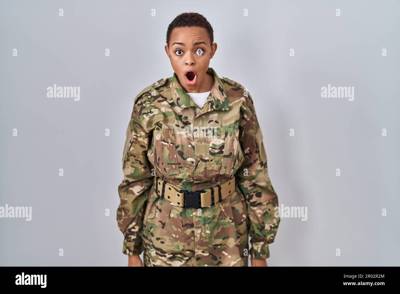 Beautiful african american woman wearing camouflage army uniform afraid ...