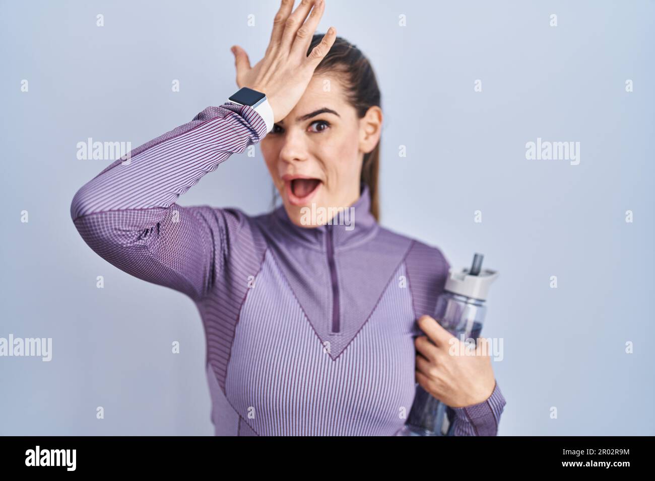 Beautiful Woman Wearing Sportswear Holding Water Bottle Surprised With