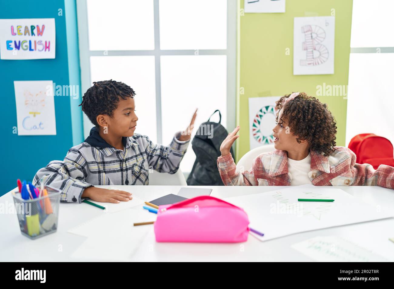 Adorable african american boy and girl students drawing on notebook ...