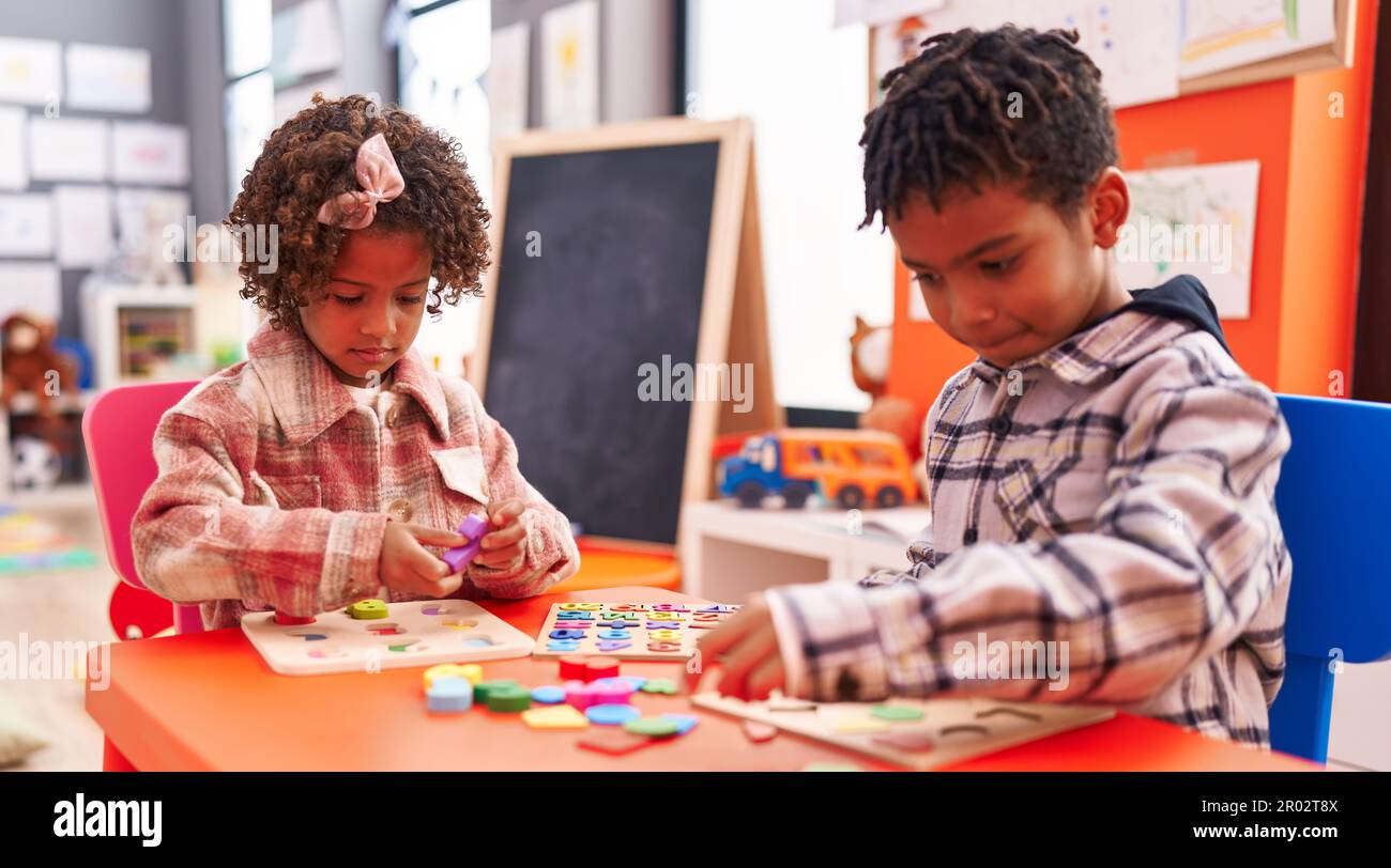 Adorable african american boy and girl playing with maths puzzle game ...