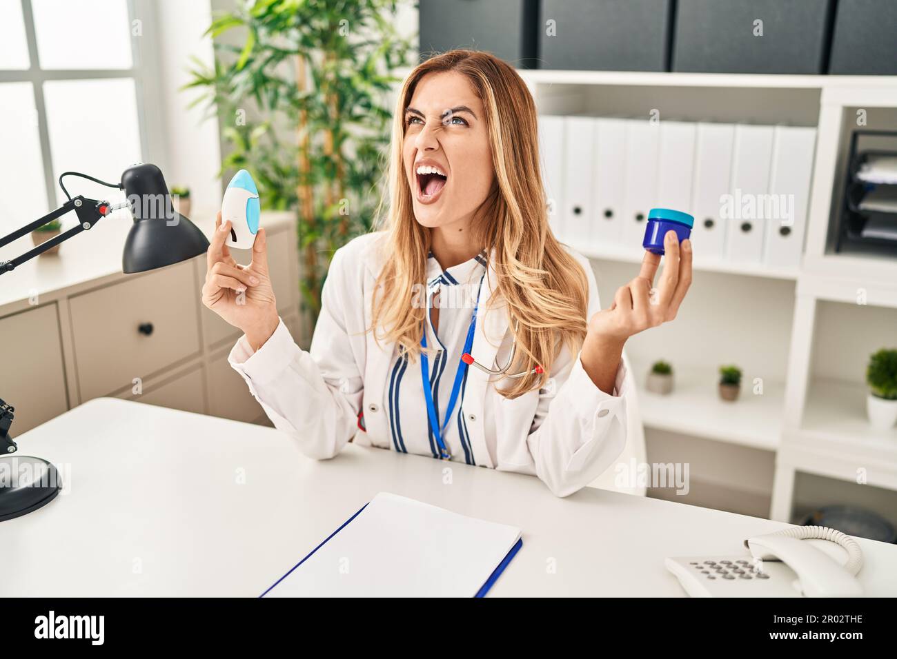 Young blonde doctor woman holding medicine products to breath better ...
