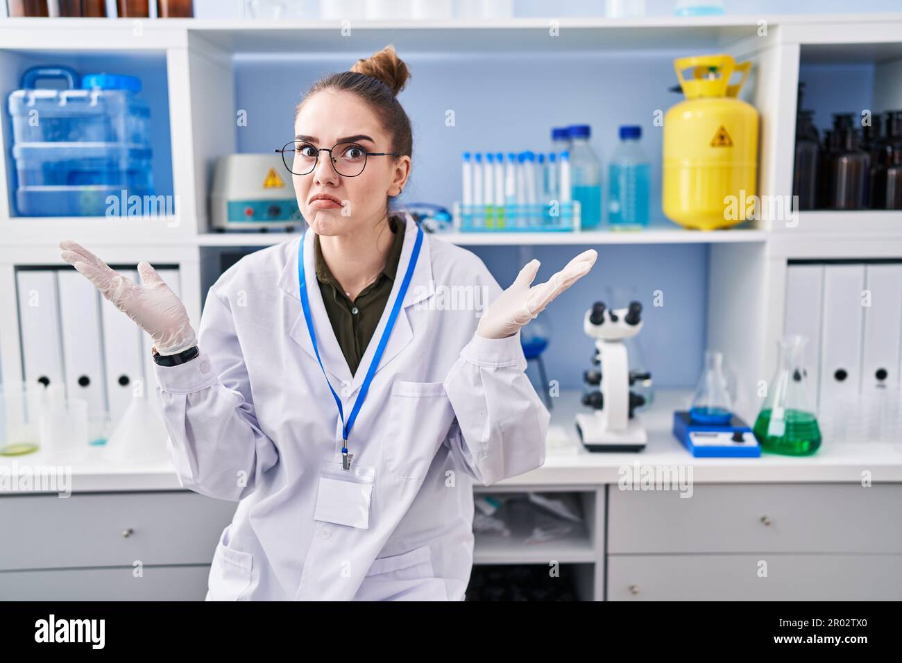 Young hispanic girl working at scientist laboratory shouting and ...