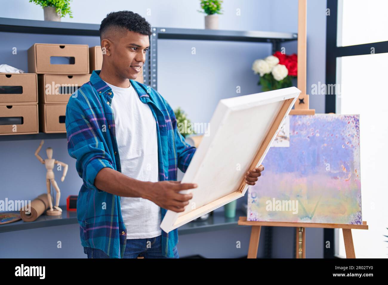 Young latin man artist smiling confident looking draw at art studio ...