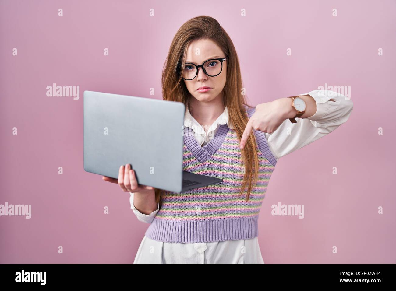 Young caucasian woman working using computer laptop pointing down ...