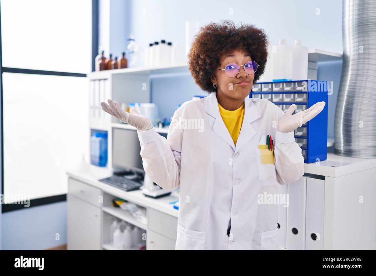 Young african american woman working at scientist laboratory shouting ...