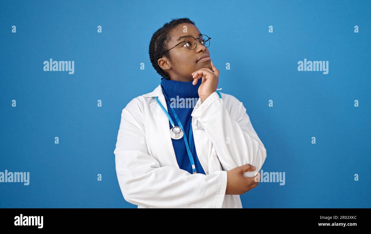 African american woman doctor standing with doubt expression thinking ...