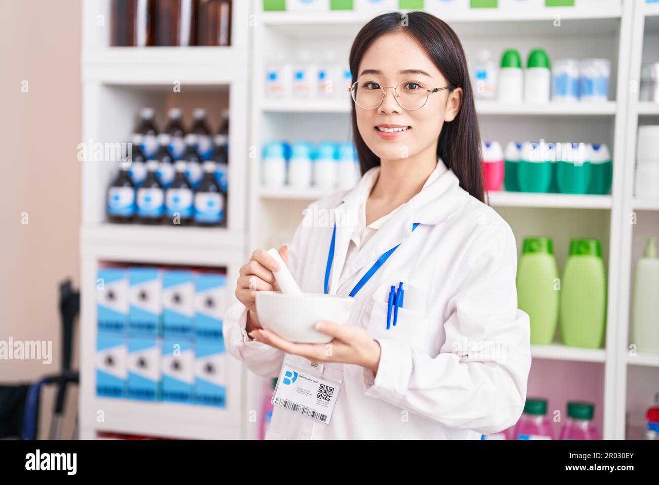 Young chinese woman pharmacist smiling confident make mixture at ...
