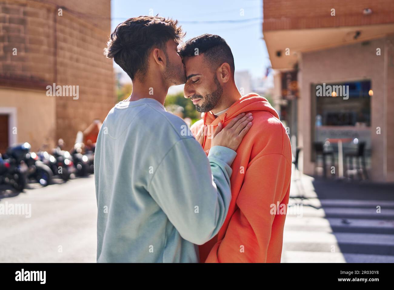 Two man couple hugging each other standing at street Stock Photo - Alamy