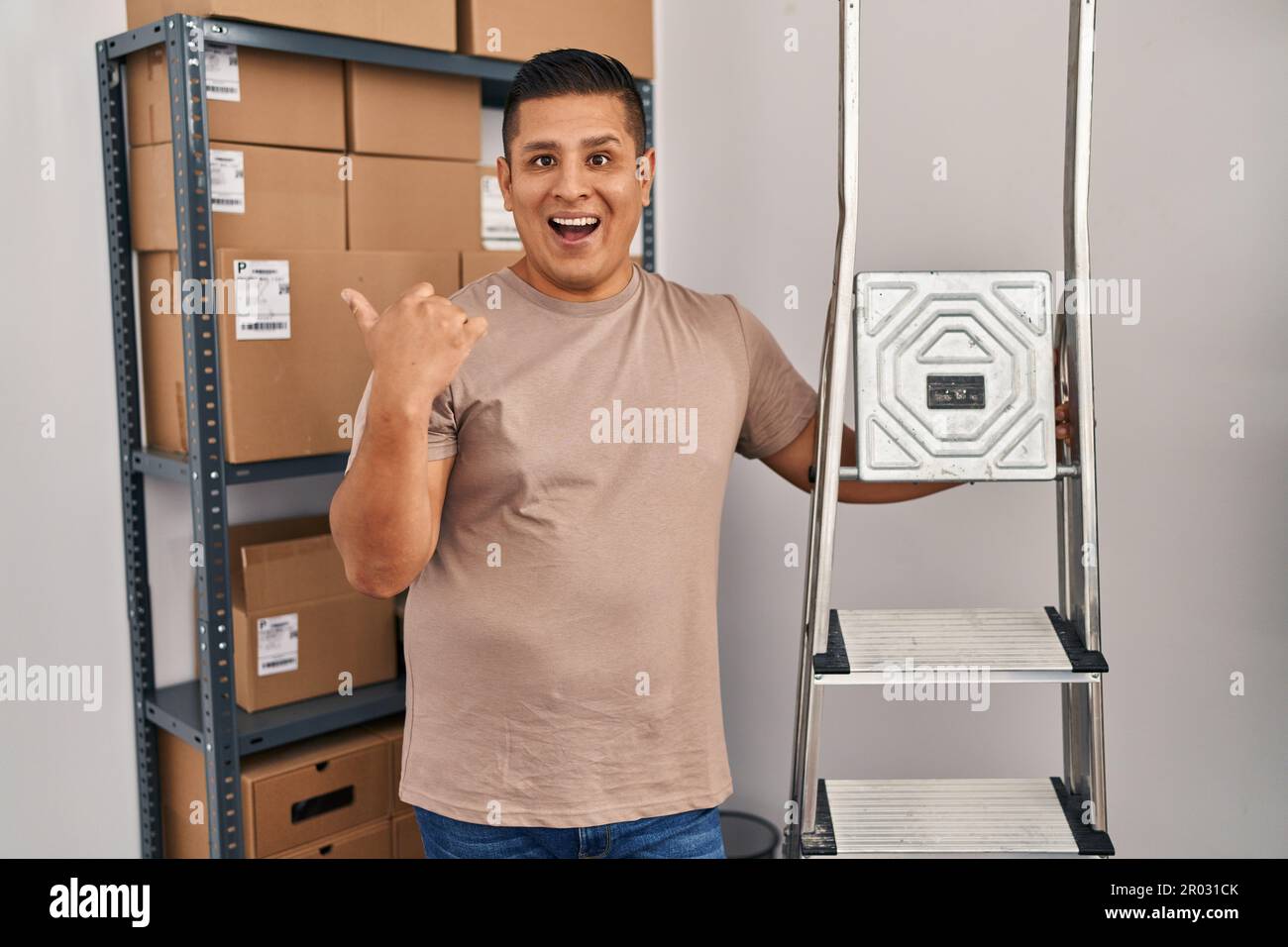 Hispanic young man working at small business ecommerce holding ladders ...