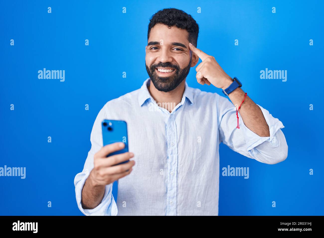 Hispanic Man With Beard Using Smartphone Typing Message Smiling