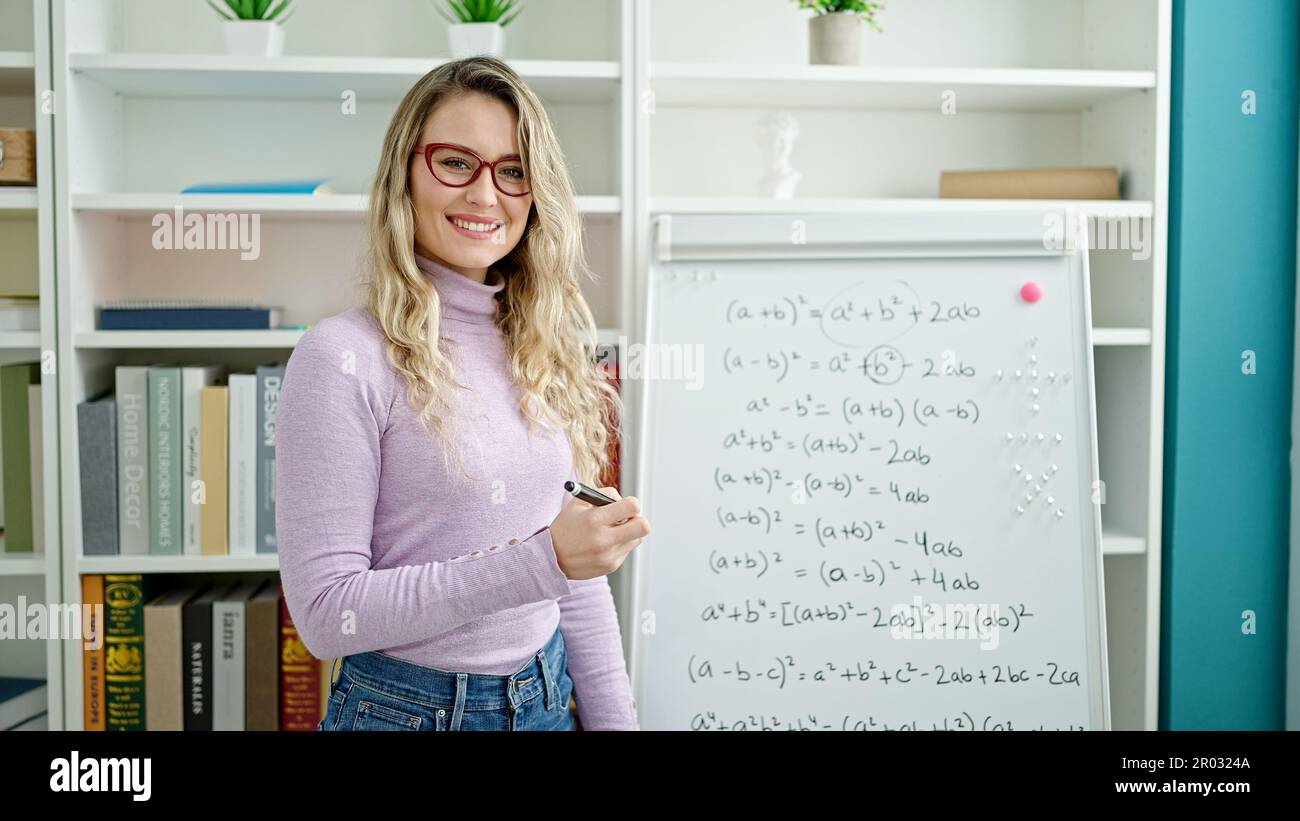 Young blonde woman teacher teaching maths lesson at classroom Stock ...