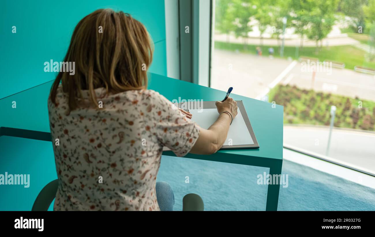 Woman sitting alone large window hi-res stock photography and images ...