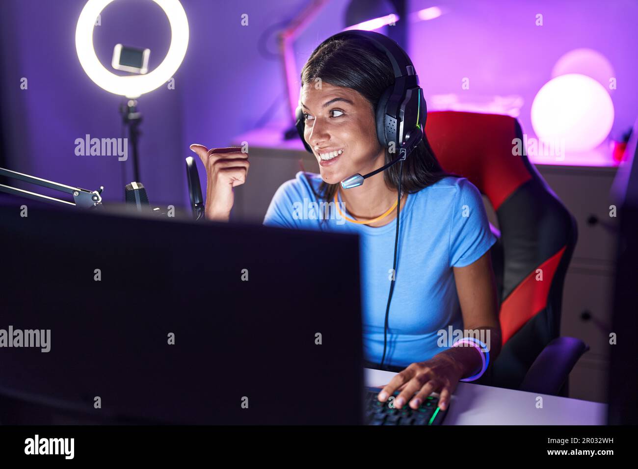 Brunette young woman playing video games smiling with happy face ...