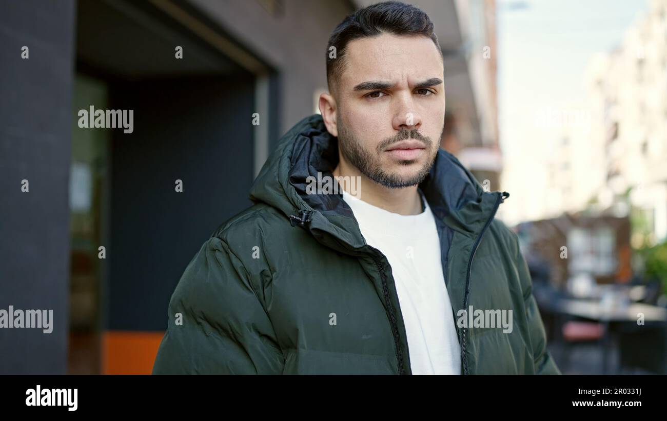 Young hispanic man standing with serious expression at street Stock ...