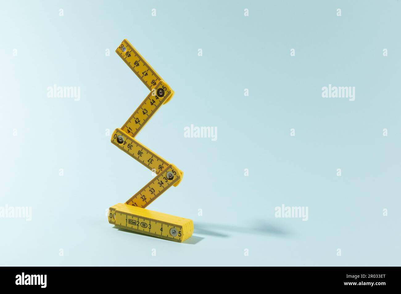A carpenters ruler on cyan background Stock Photo - Alamy