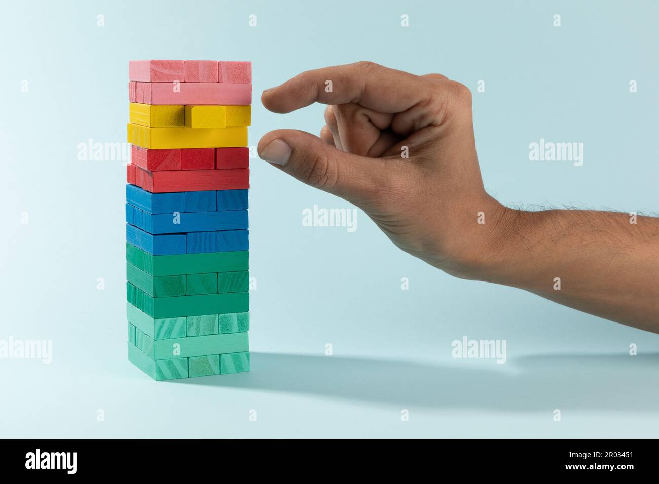 Block tower made of colourfull wooden blocks on light blue background ...