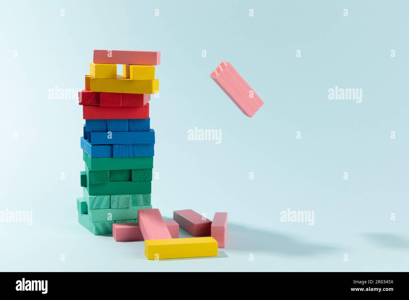 Block tower made of colourfull wooden blocks on light blue background ...