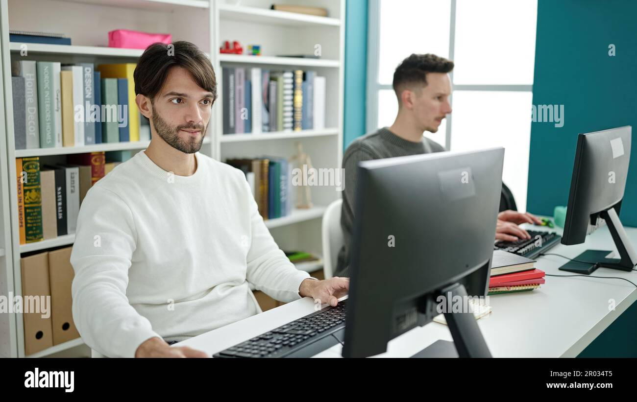 Two men students using computer studying at library university Stock ...