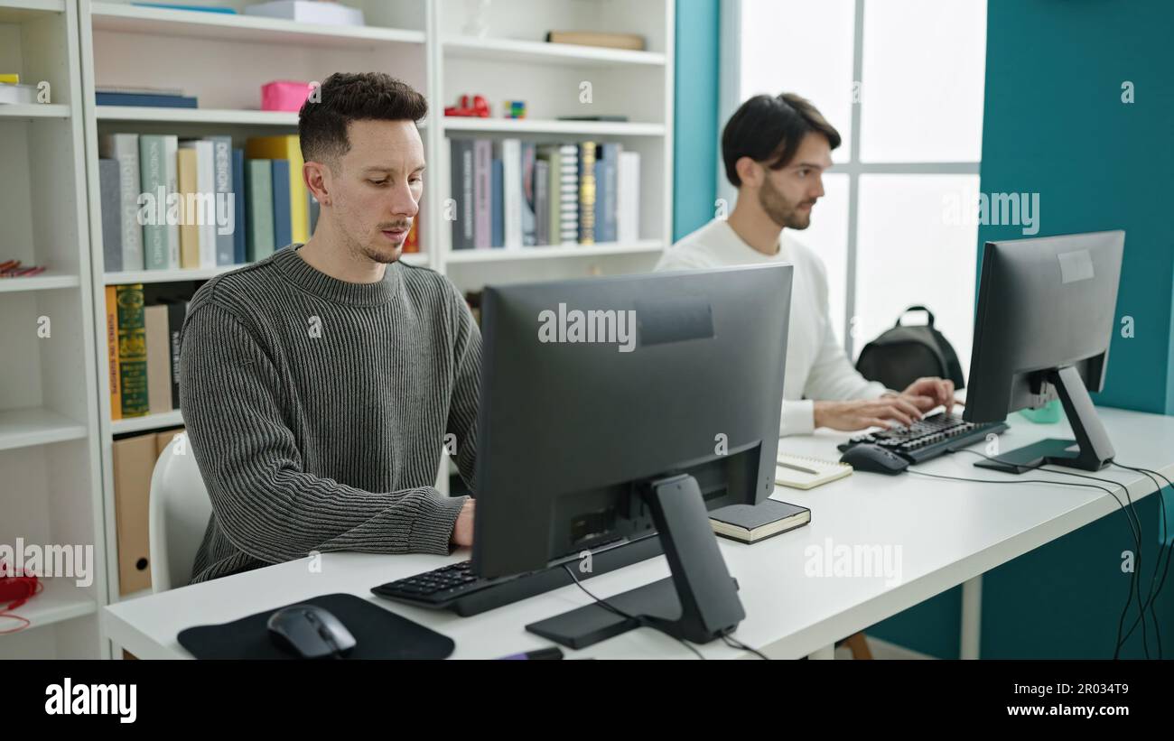 Two men students using computer studying at library university Stock ...