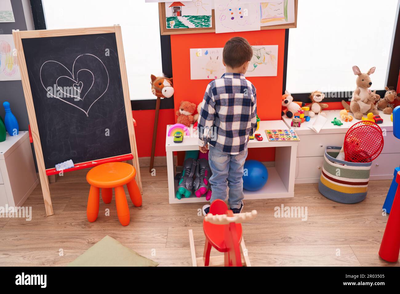 Adorable caucasian boy playing on back view at kindergarten Stock Photo ...