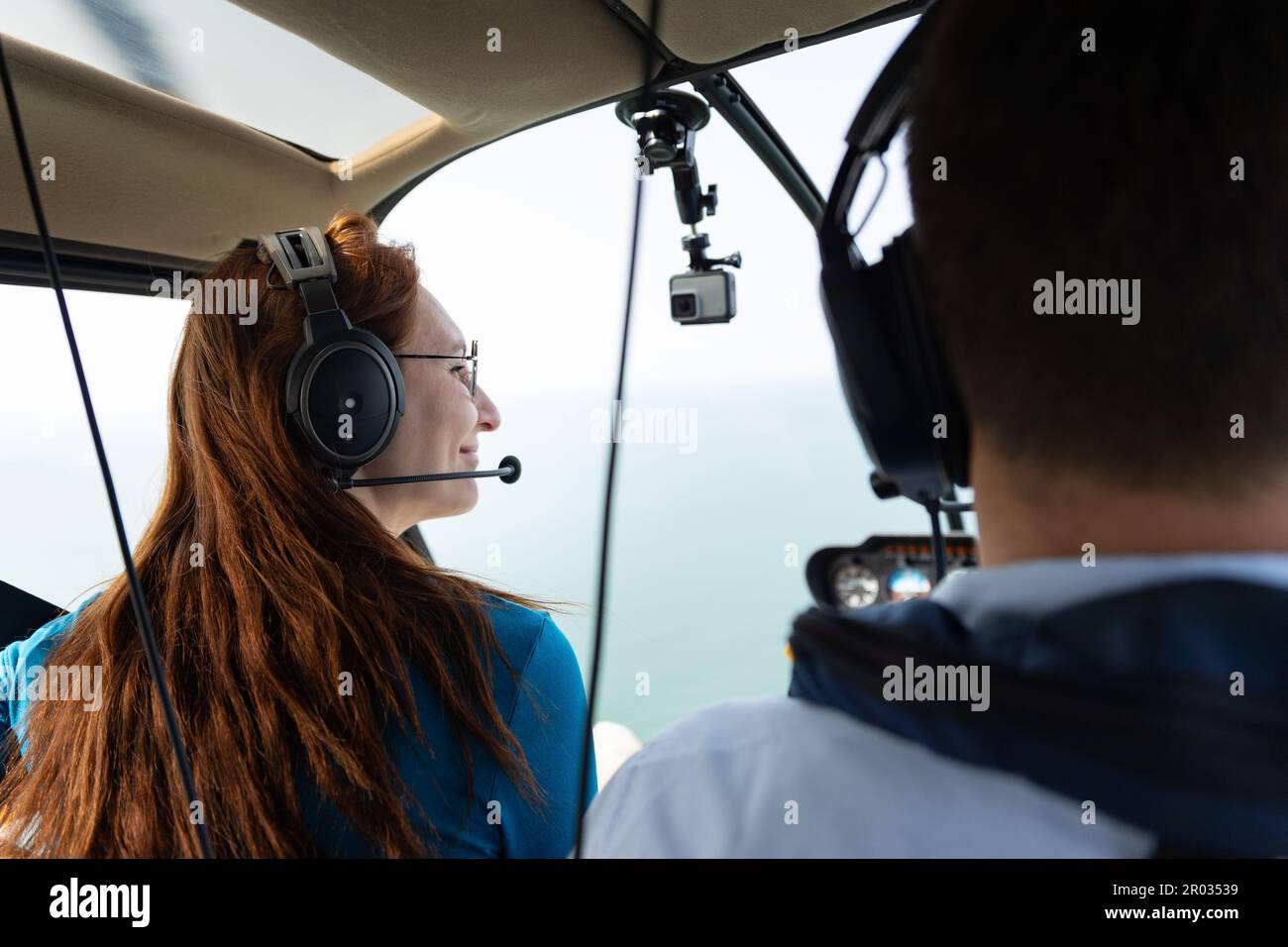Smiling woman sitting in passenger seat in helicopter Stock Photo - Alamy