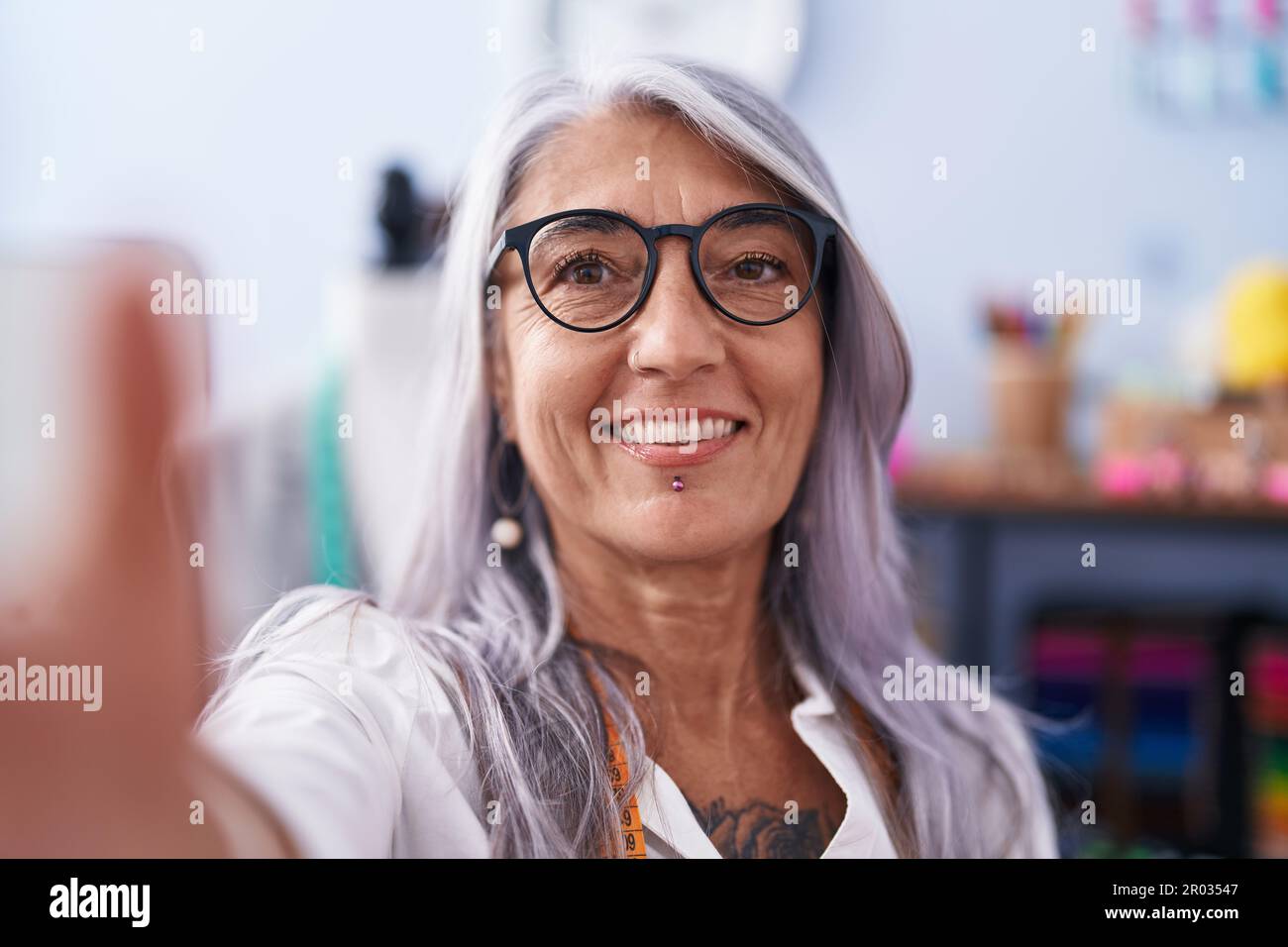 Middle age grey-haired woman tailor smiling confident make selfie by ...