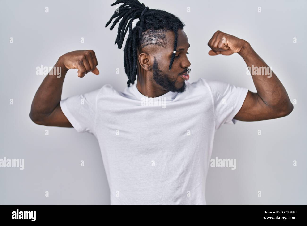 African man with dreadlocks wearing casual t shirt over white ...
