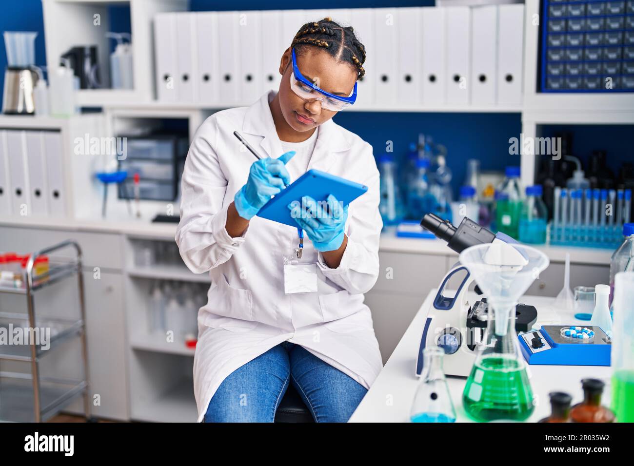 African american woman scientist using touchpad at laboratory Stock Photo - Alamy